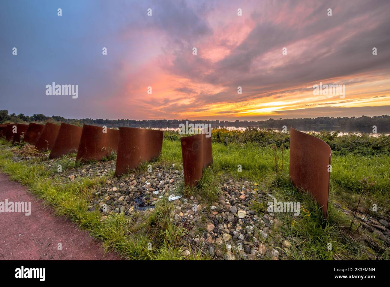 Rusty Metal curved objects in landscape with lake and sunset at ...