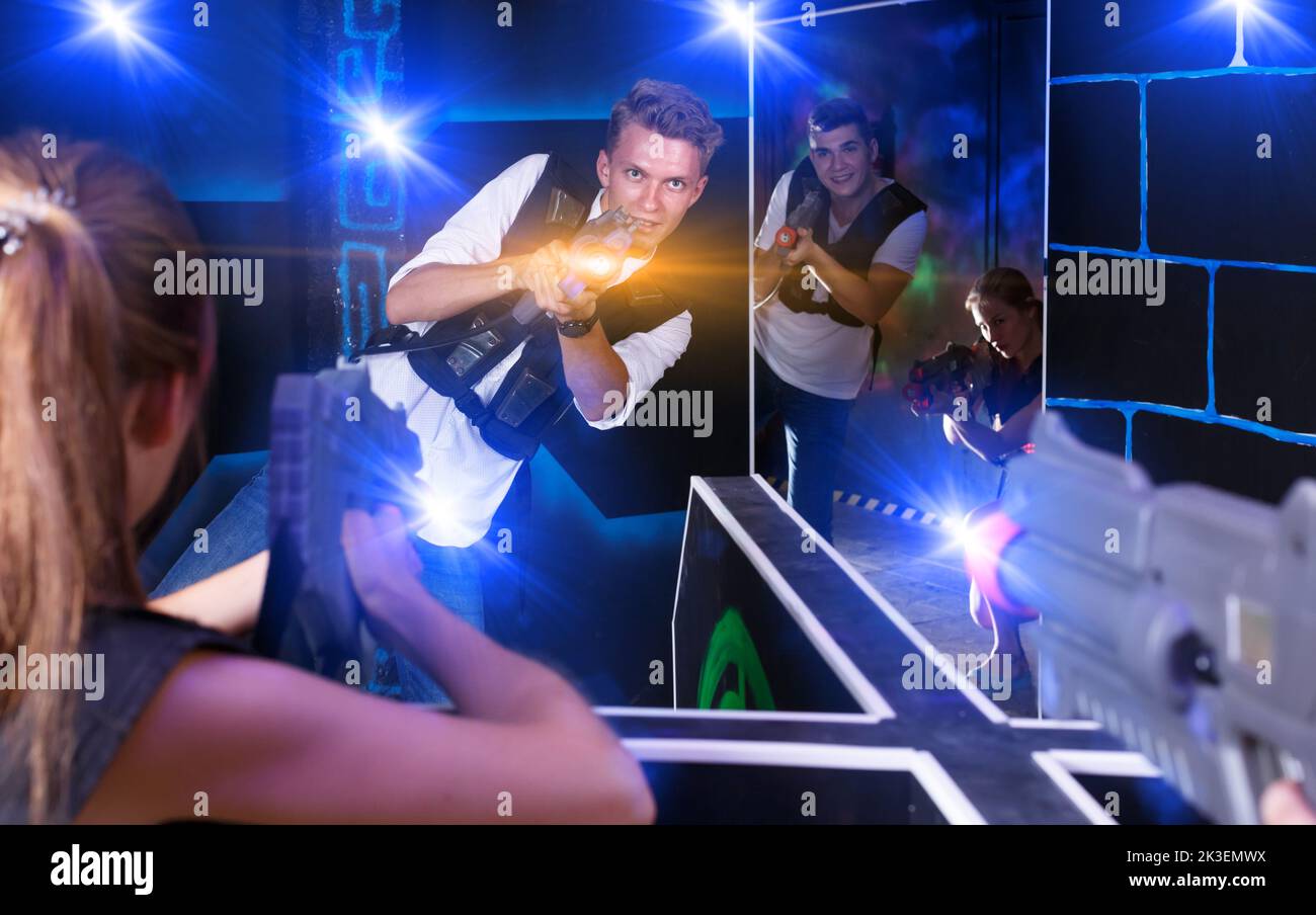 Positive girls and guys playing laser tag game opposite each o Stock ...
