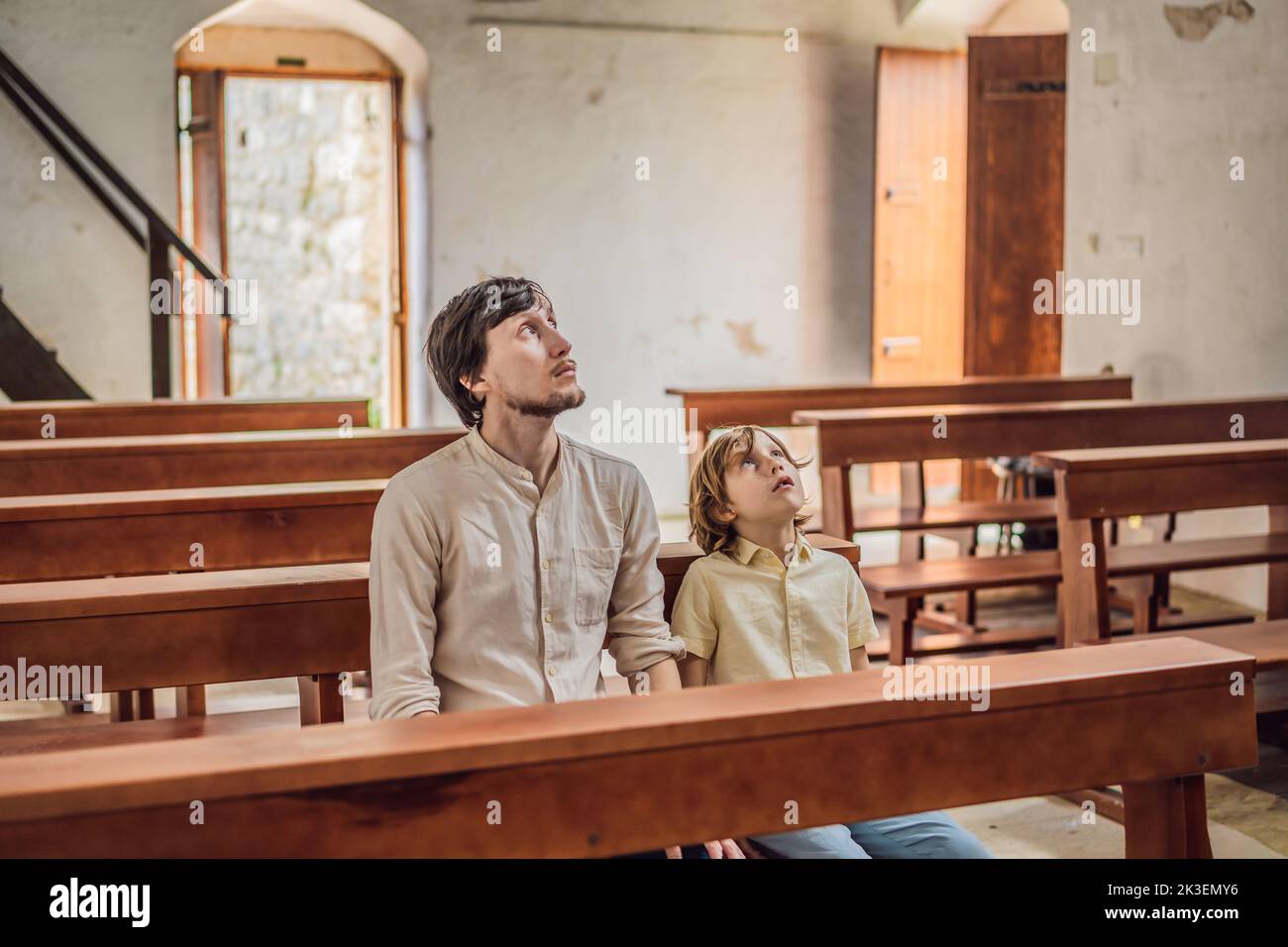 Christian dad tells his son Bible stories about Jesus sitting in kirk ...