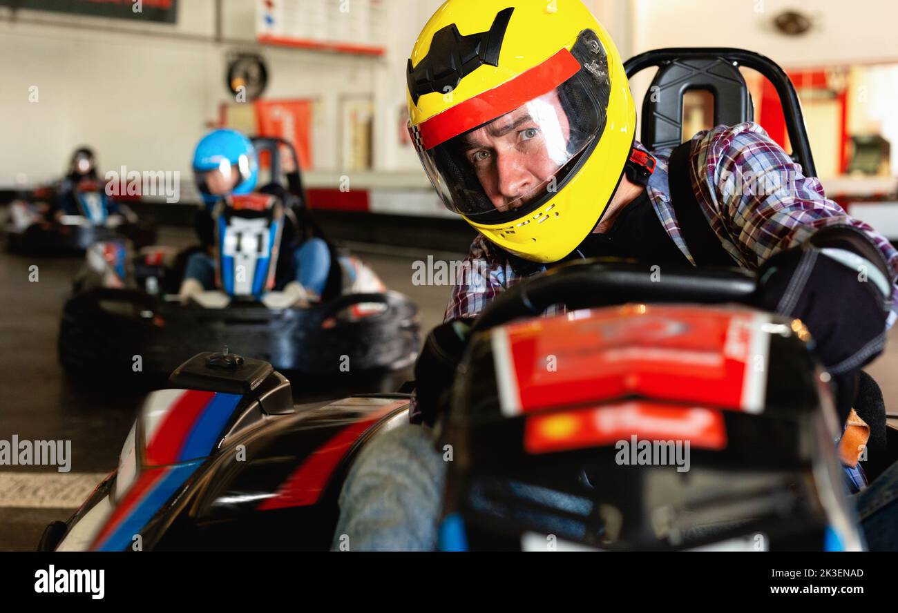 Portrait of male racer in helmet driving kart on track Stock Photo - Alamy
