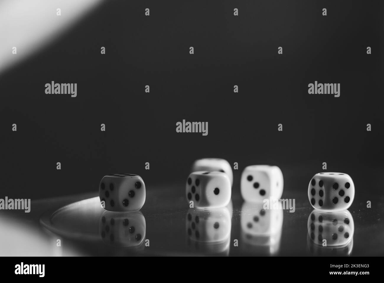 Playing dice on glass with reflections in it. Black and white photo ...