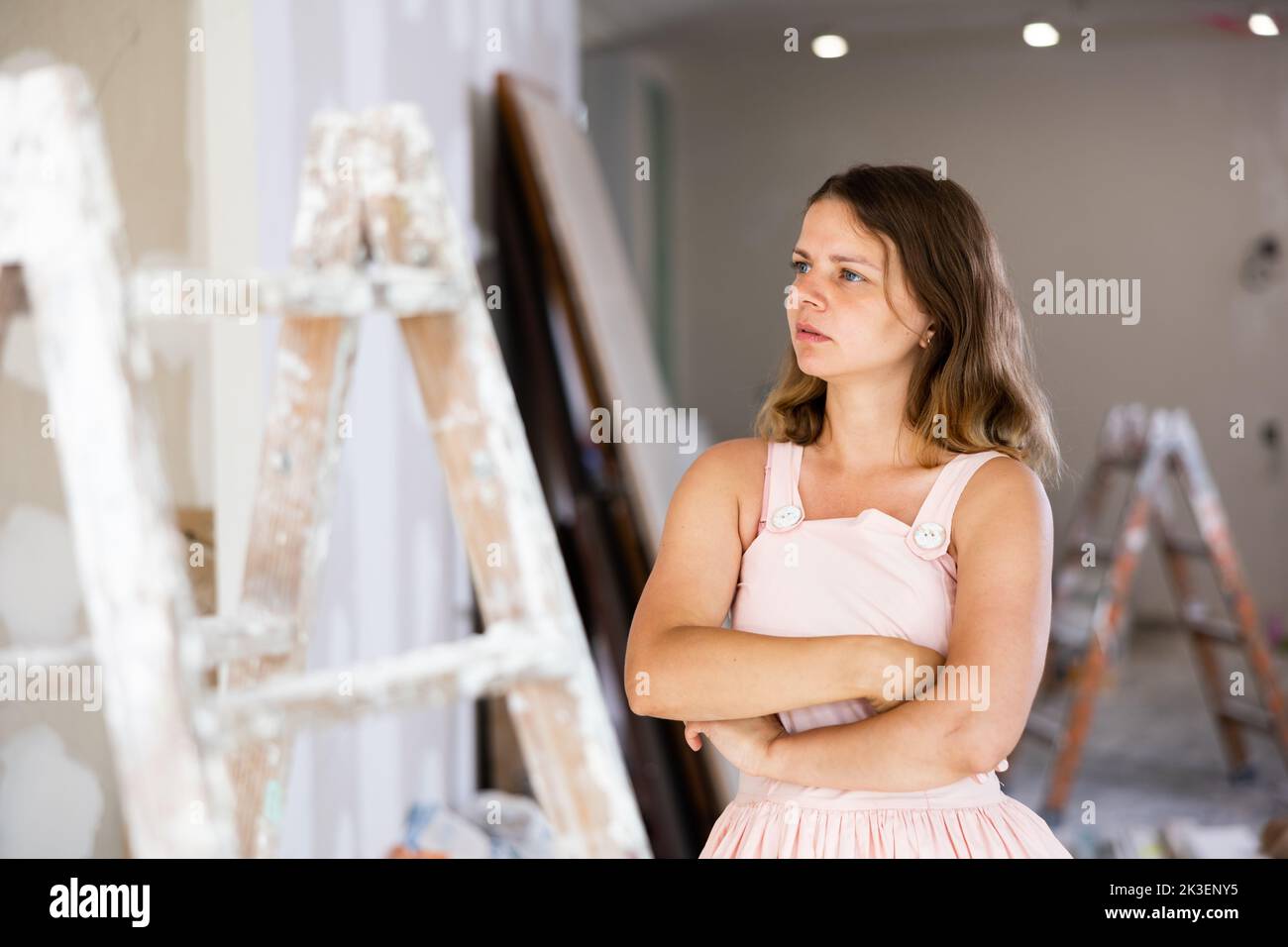 Female owner of the cottage in a beige dress checks the quality of room ...