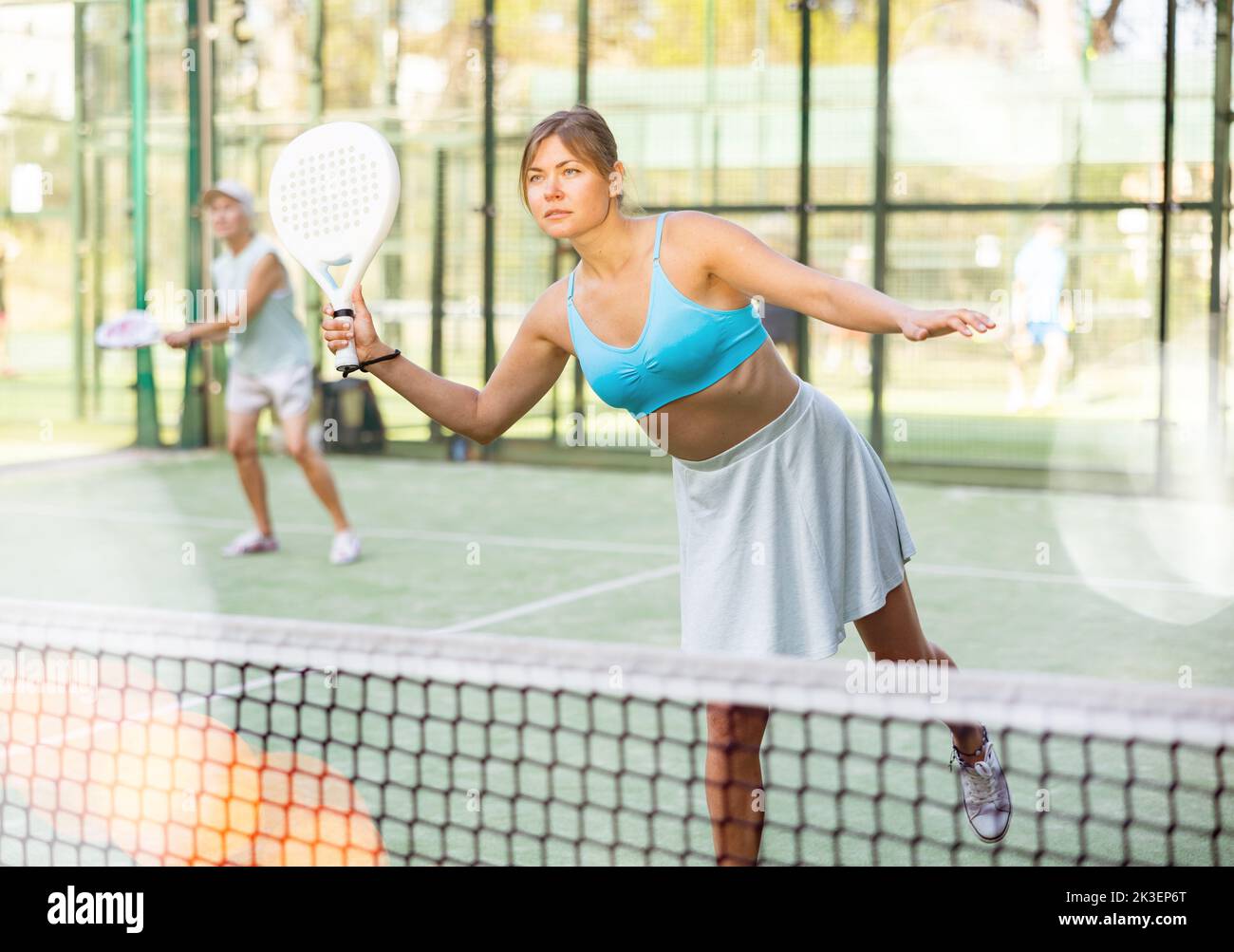 Sporty young woman playing padel on open court on summer Stock Photo ...