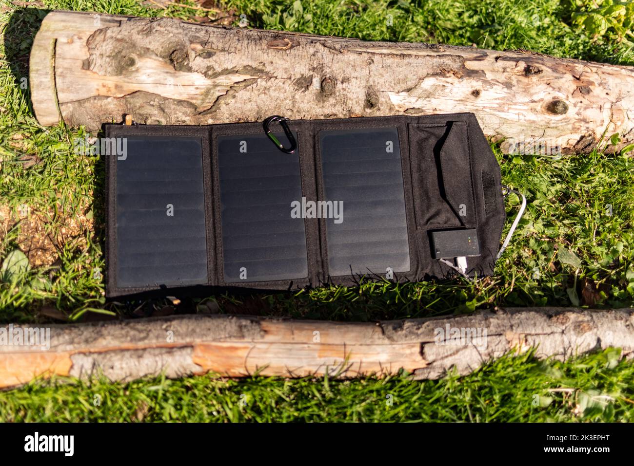 Recharging a compact solar panel. Charging a tourist solar battery on a ...