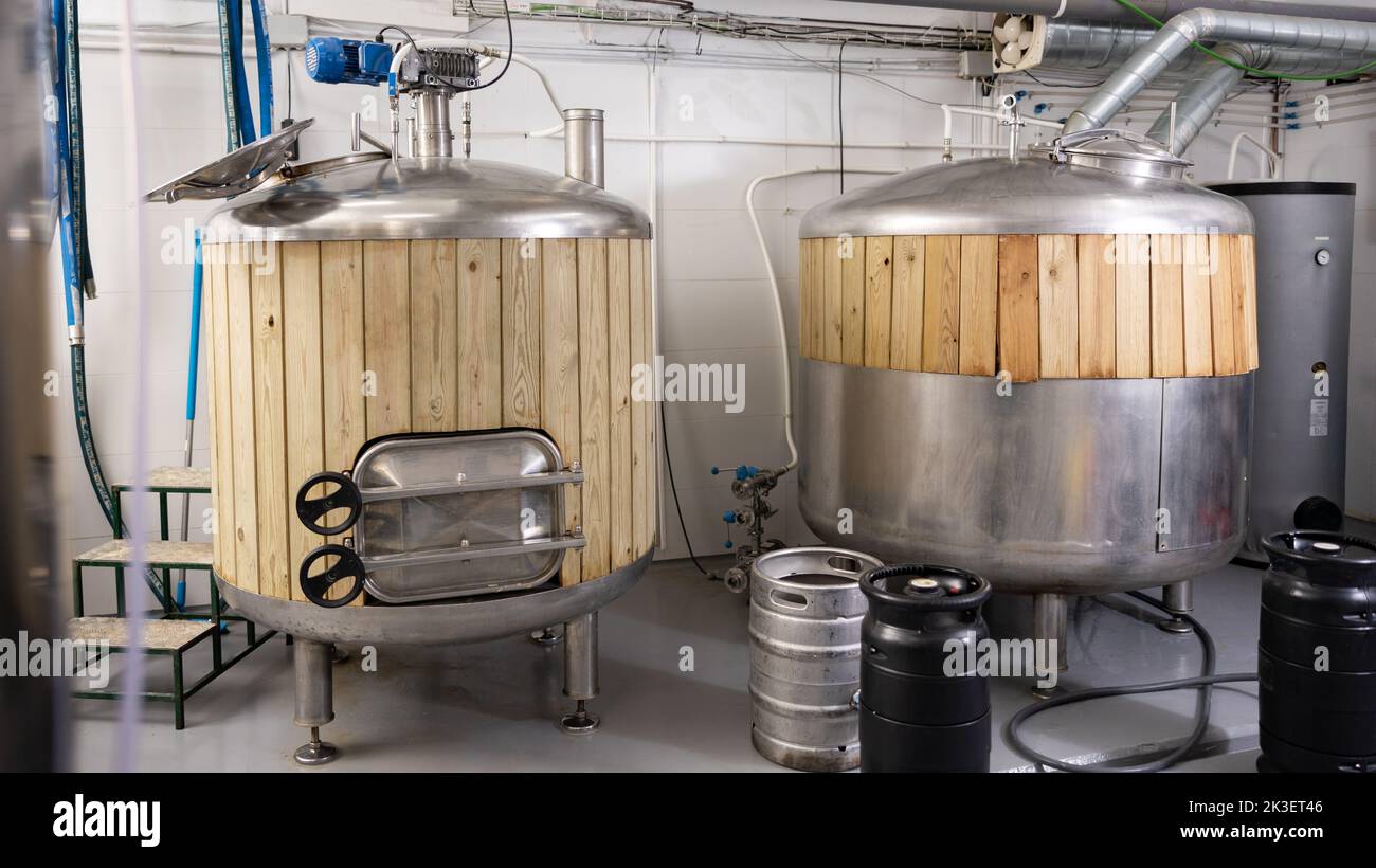Interior of small brewery with tanks for beer fermentation and kegs ...