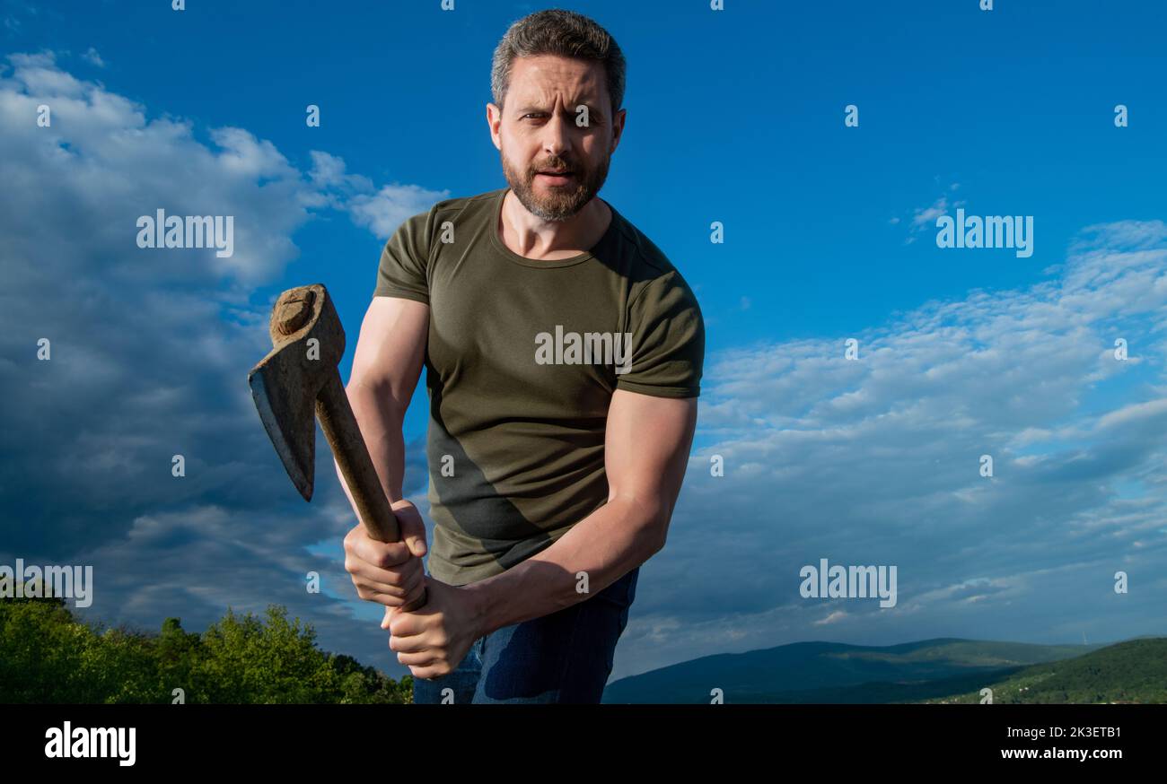 man threaten with axe. aggressive man hold ax. brutal man on sky ...