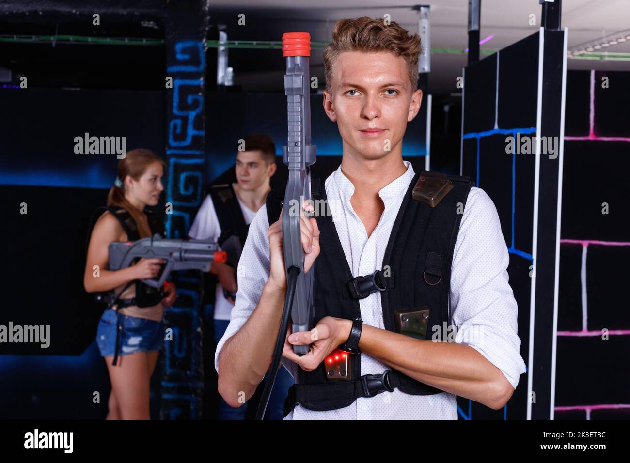 Portrait of excited guy with laser pistol playing laser tag in a Stock ...