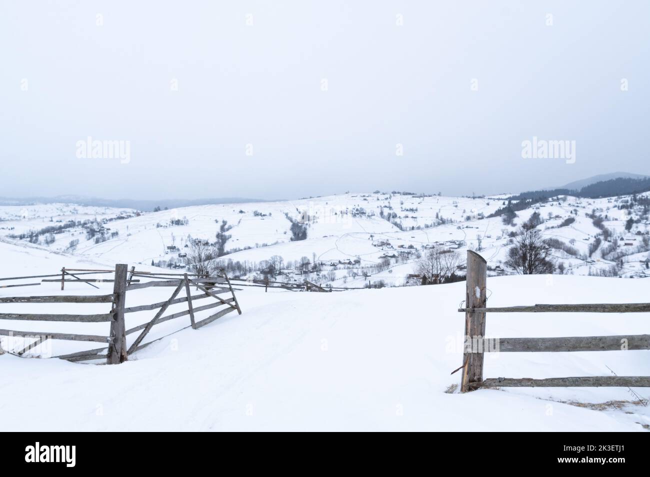 Wooden gate in the snowy mountains. Snow-capped mountains and fields ...