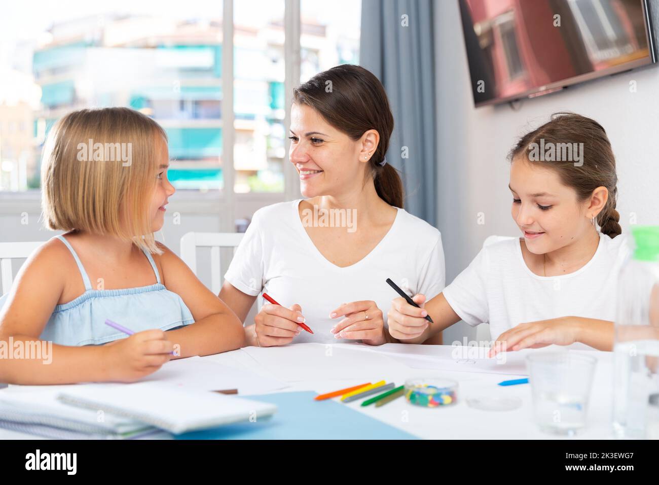 Happy mother teaches her daughters to draw Stock Photo - Alamy