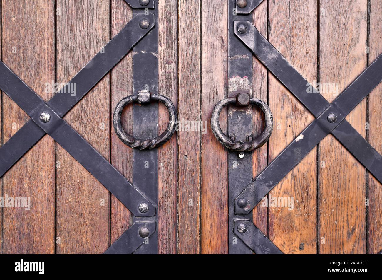 Weathered wood door with handles and iron bars Stock Photo - Alamy