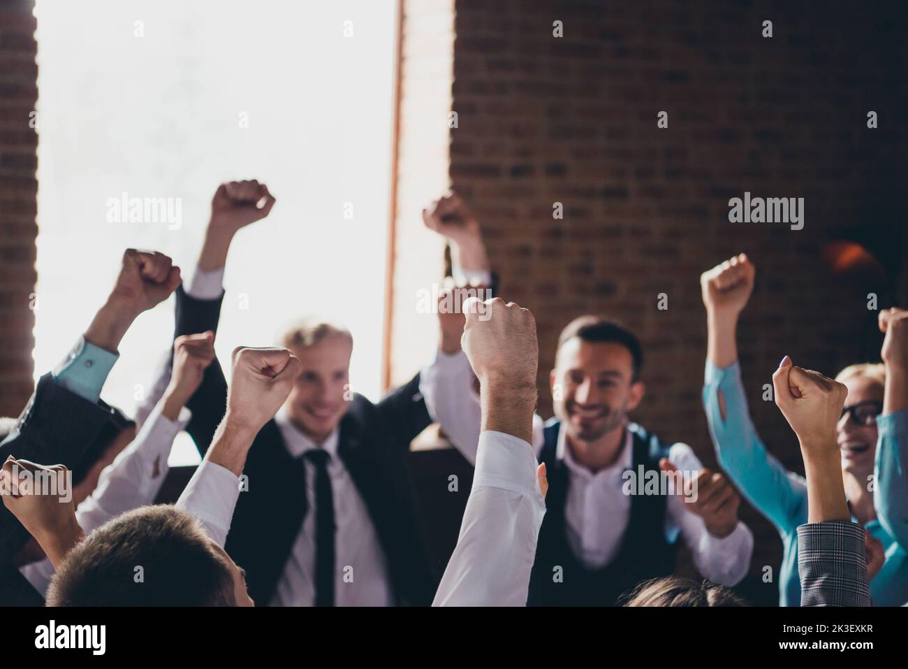 Photo of delighted business people raise hands fists up celebrate luck ...