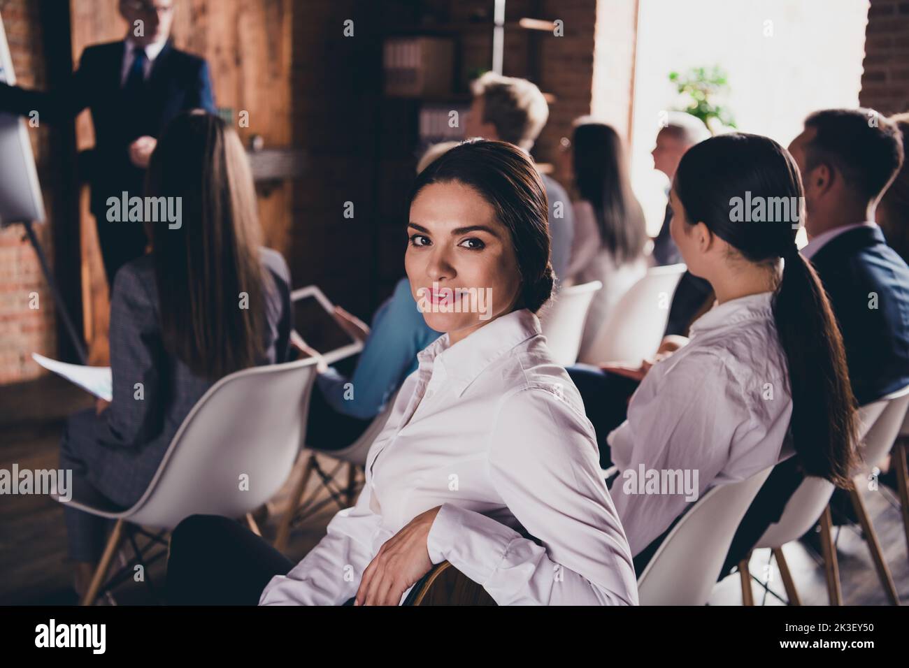 Businesspeople at corporate event listening to presenter studying new ...