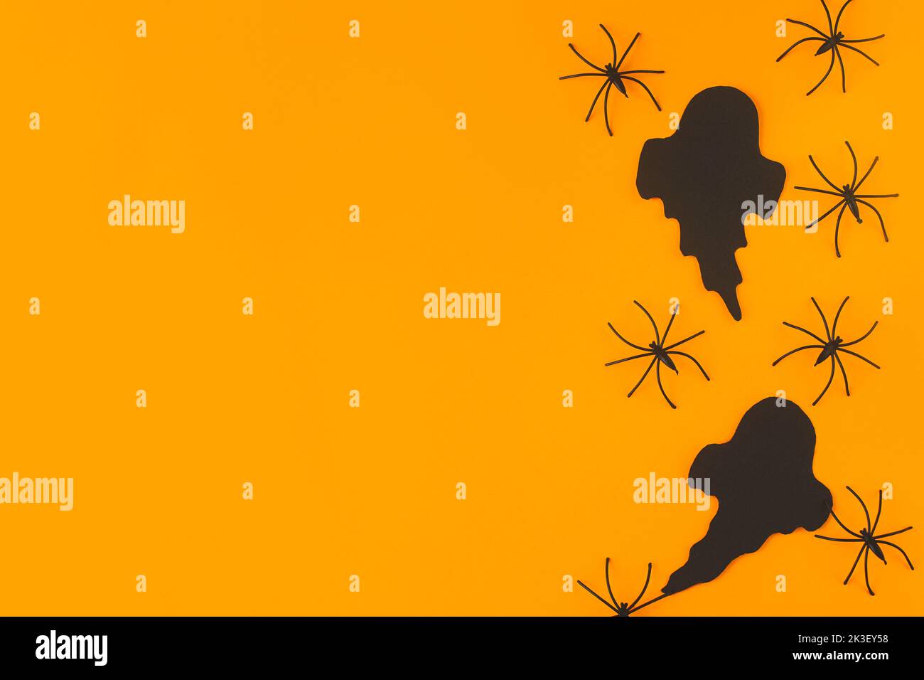 Happy Halloween! Black ghosts and spiders flat lay on orange background ...
