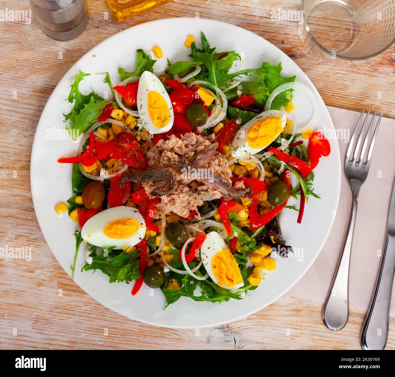 Corn, olive, anchovy, pepper, lettuce salad served on plate Stock Photo ...