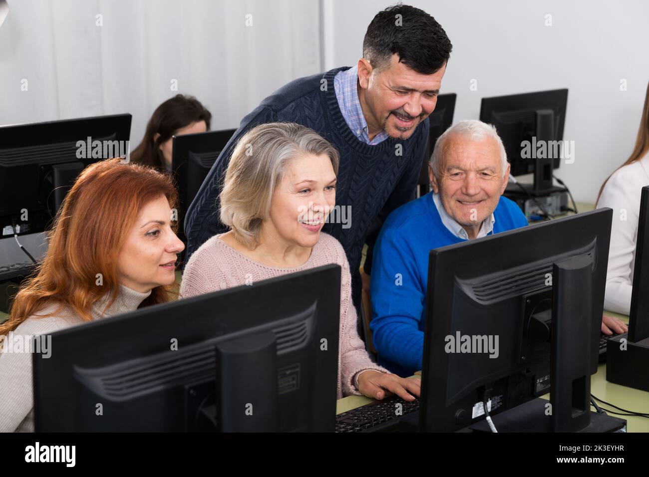 Business people grouped around laptop hi-res stock photography and ...