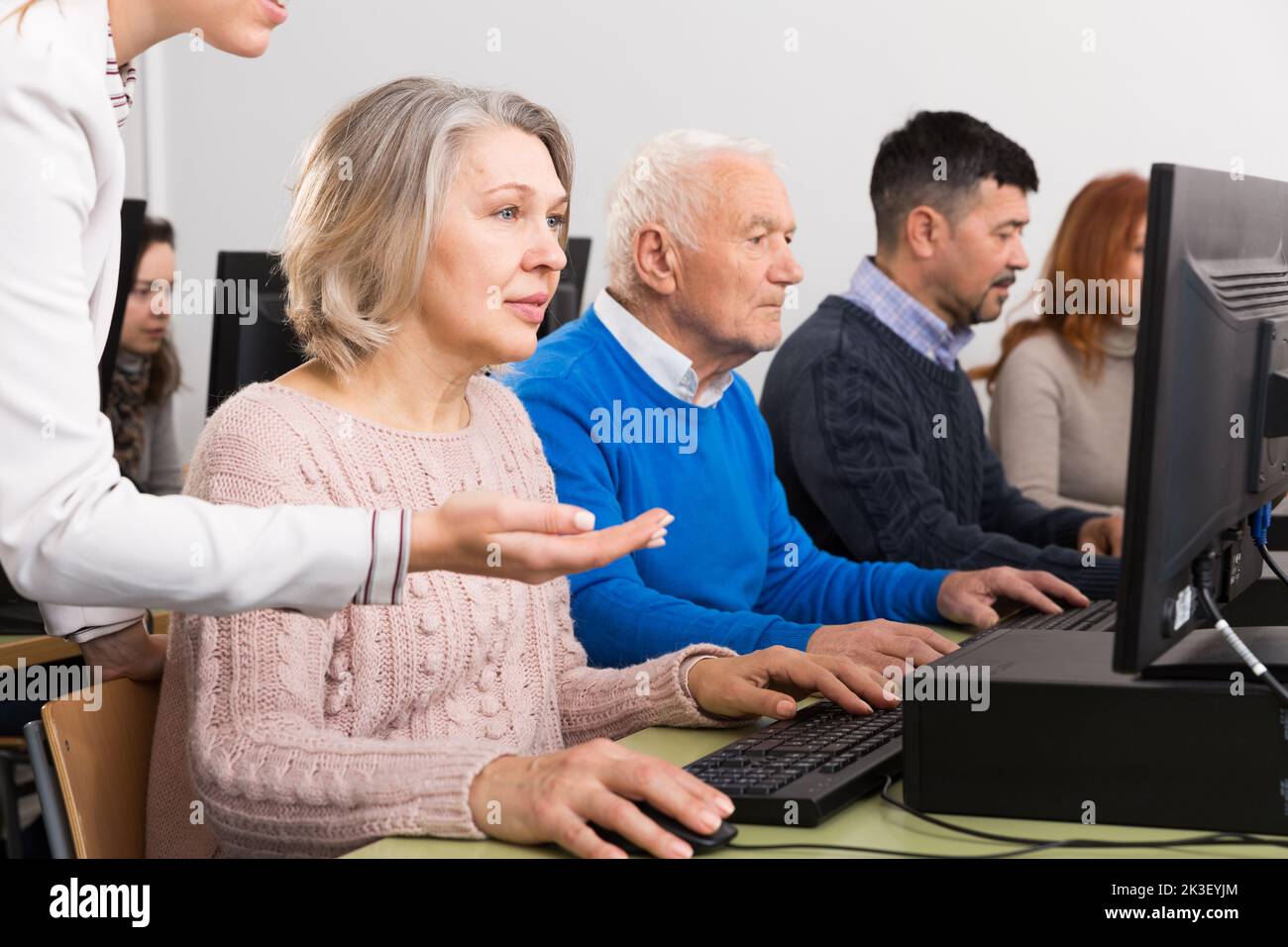 Side view of young business woman explaining something to older ...