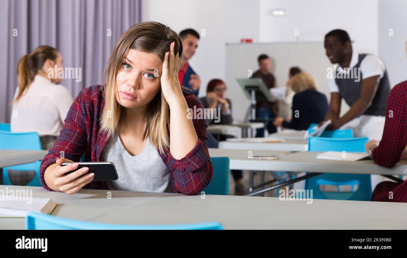 Frustrated woman student with phone Stock Photo - Alamy