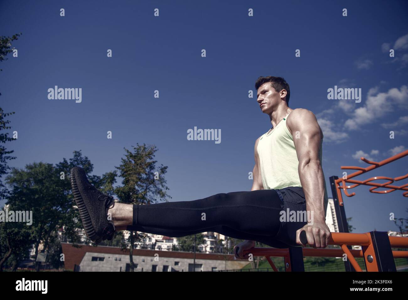 Sportsman hold raised legs straight on parallel bars, workout Stock ...
