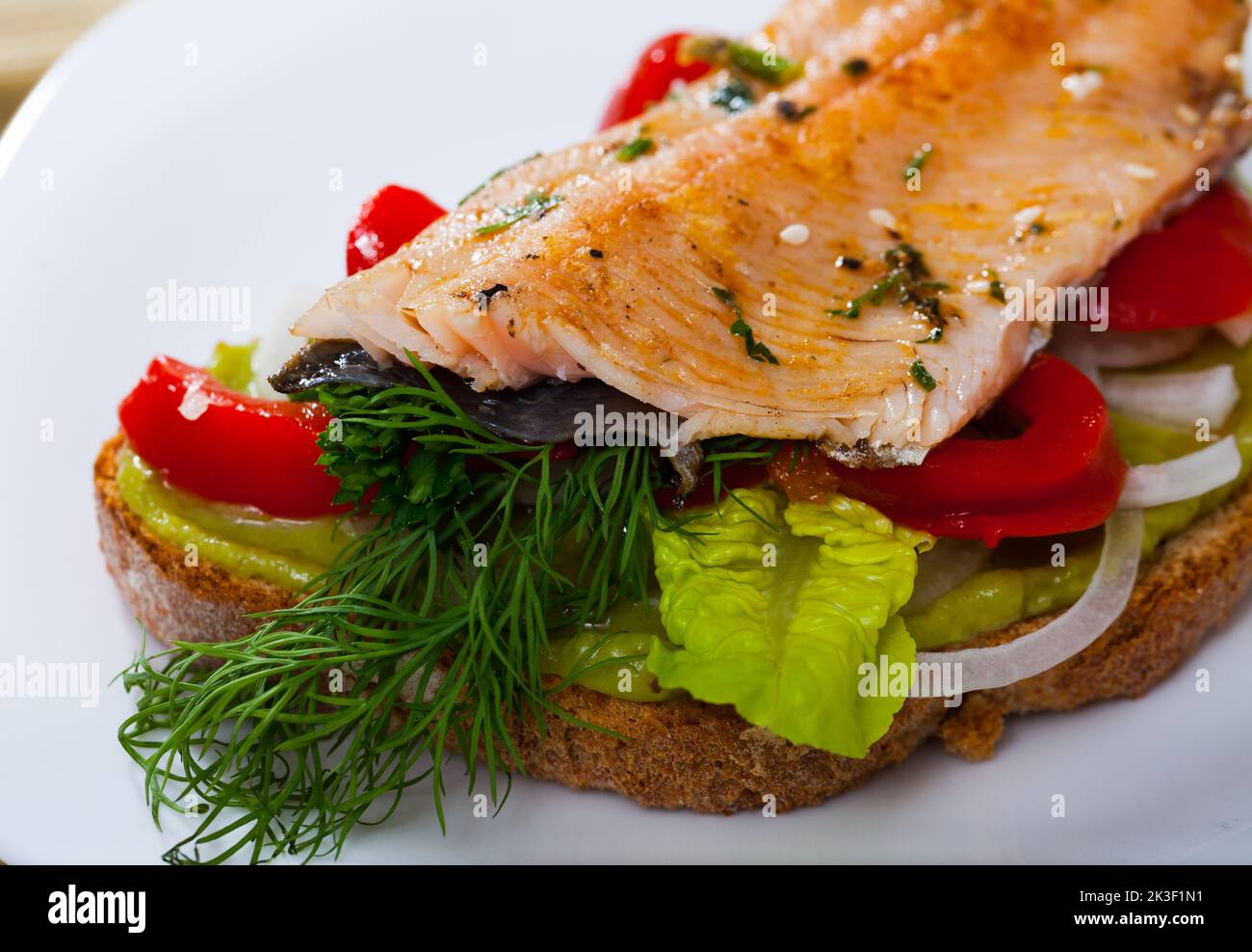 Toast with trout fillet, guacamole, bell pepper Stock Photo - Alamy