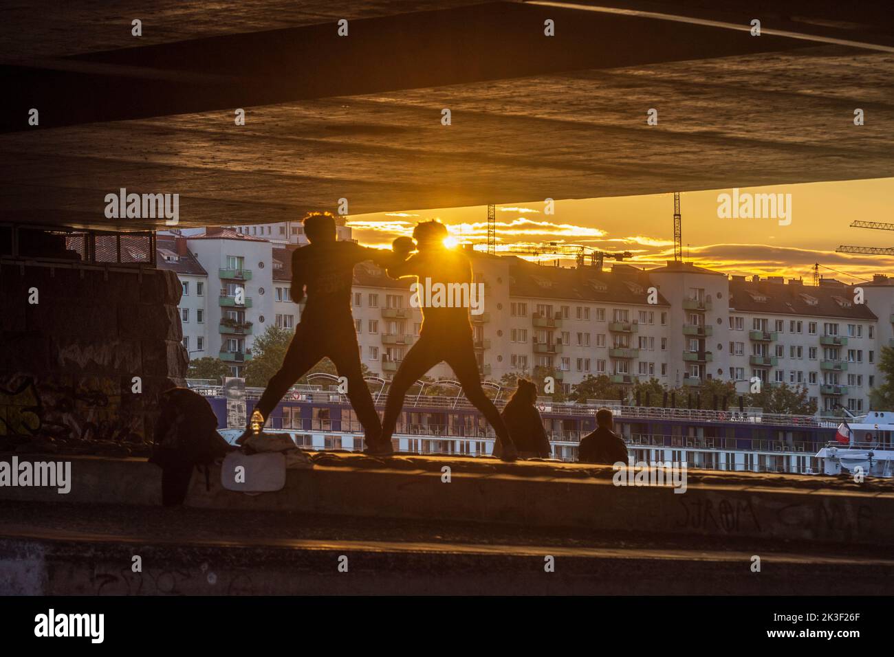 Wien, Vienna: 2 men boxing sport below bridge Reichsbrücke, sunset ...
