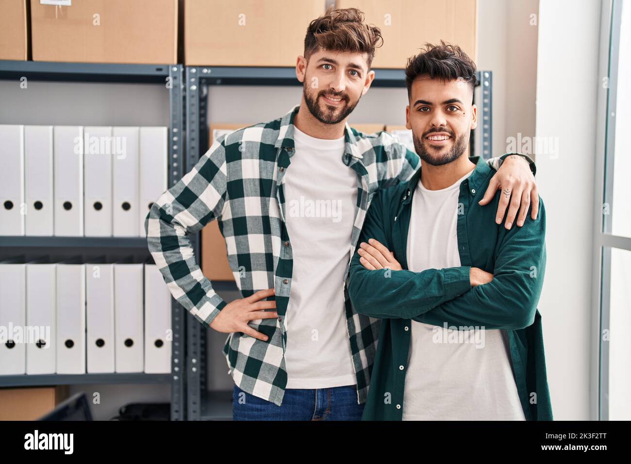 Young couple ecommerce business workers hugging each other standing at ...