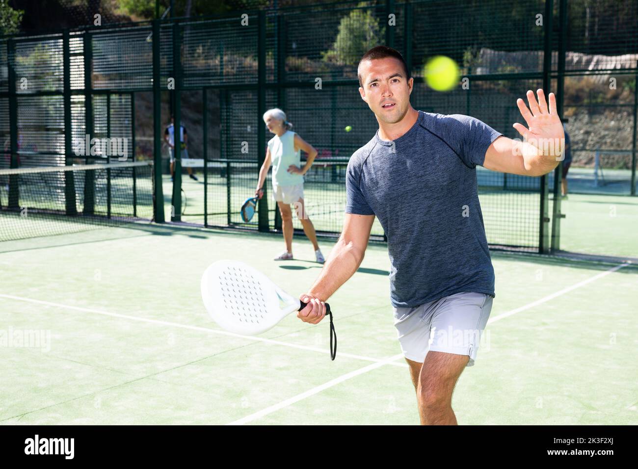 Male players playing padel in a padel court outdoor behind net Stock ...