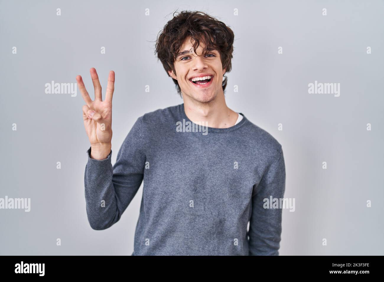 Young man standing over isolated background showing and pointing up ...