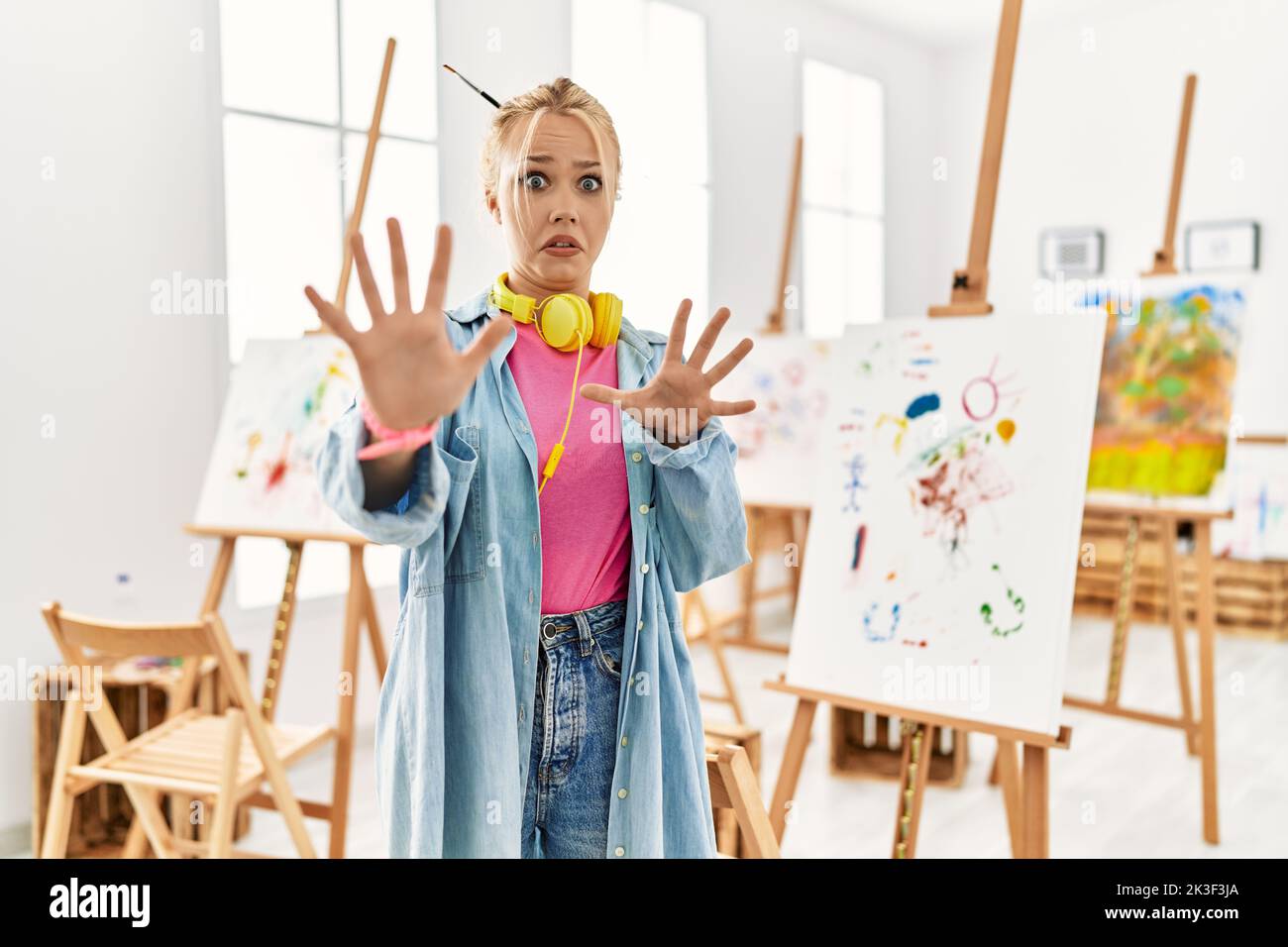 Young caucasian girl at art studio afraid and terrified with fear ...
