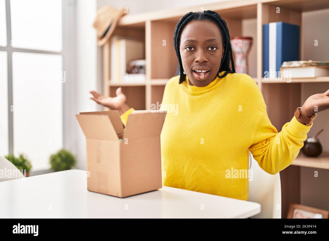 Beautiful black woman opening cardboard box shouting and screaming loud ...