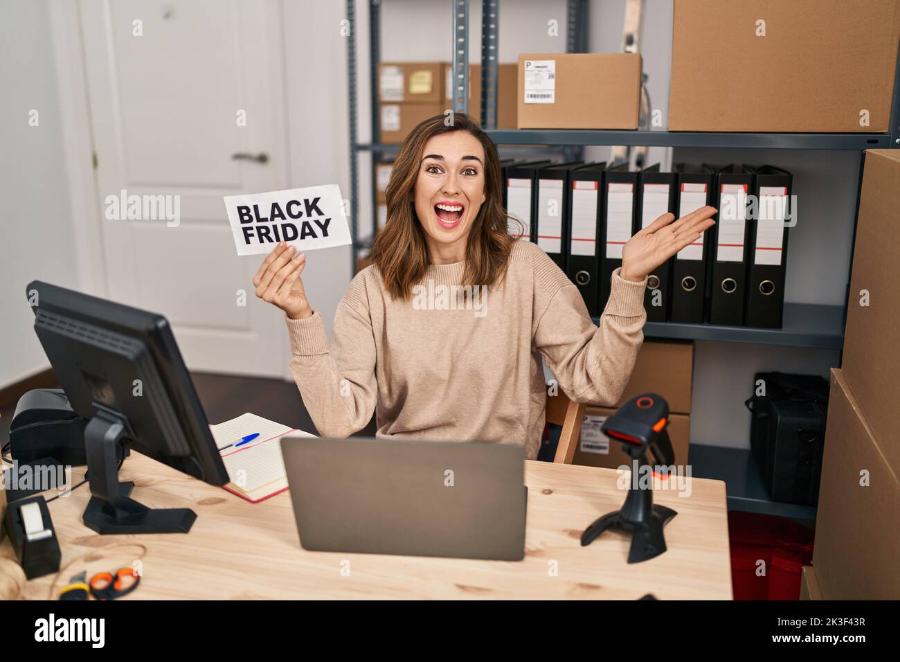 Young beautiful woman holding black friday banner small commerce ...