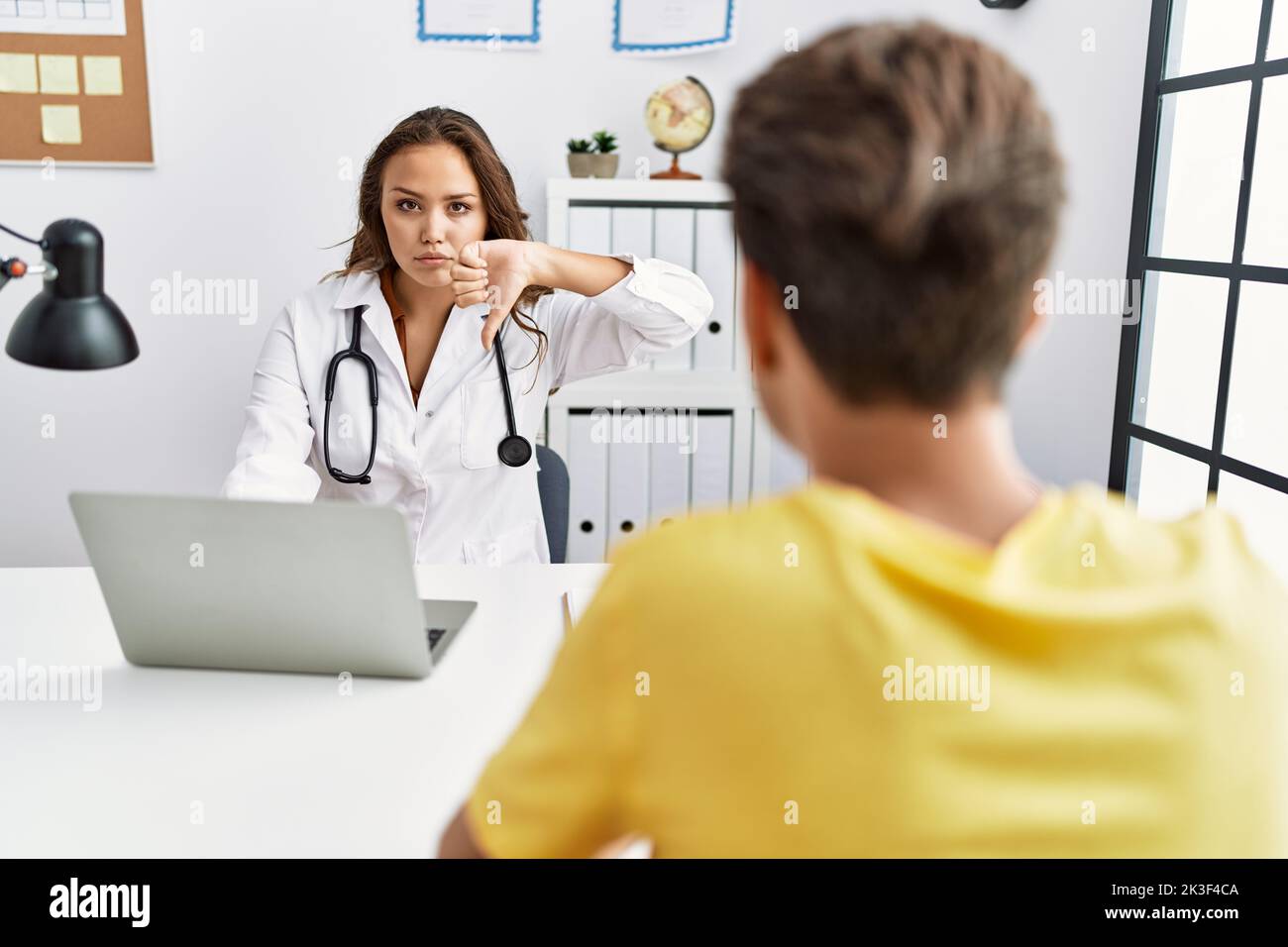 Young doctor woman with patient at the clinic with angry face, negative ...