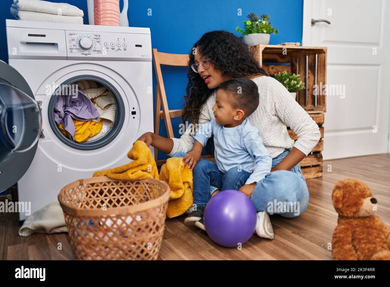 Mother and son smiling confident washing clothes at laundry room Stock ...