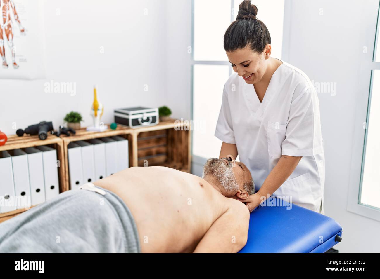 Physiotherapist and patient smiling confident having rehab session at ...