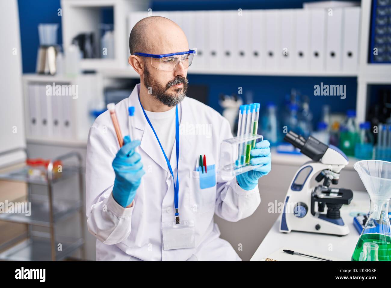Young bald man scientist holding test tubes at laboratory Stock Photo ...
