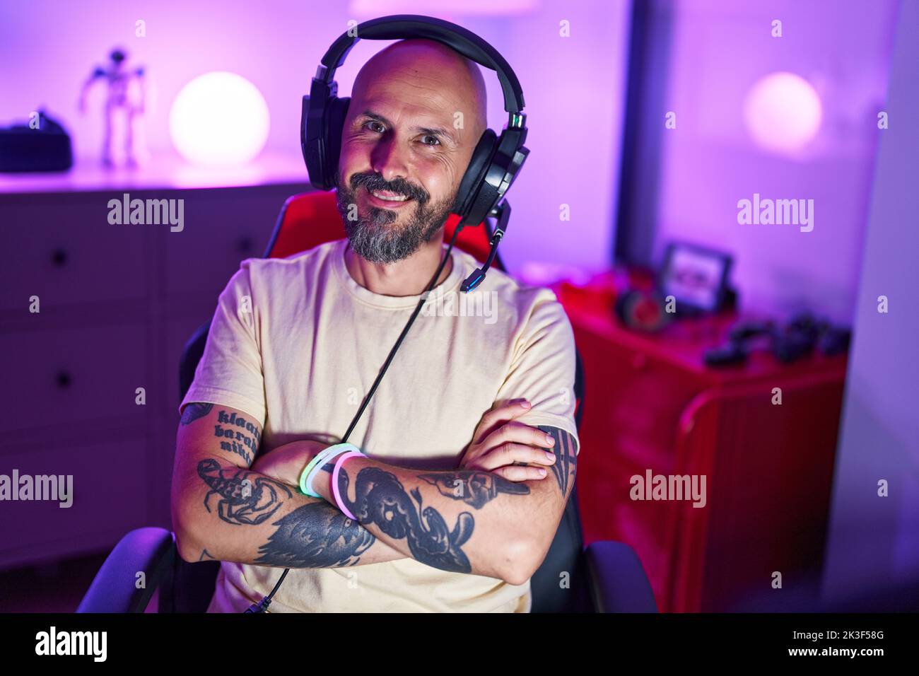 Young bald man streamer smiling confident sitting with arms crossed ...
