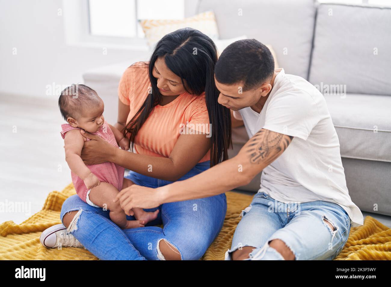 Hispanic family hugging each other sitting on sofa at home Stock Photo ...