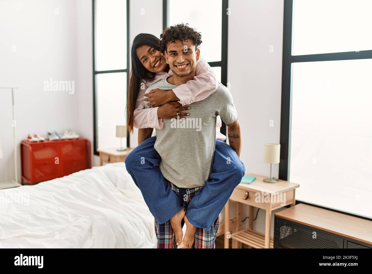 Young latin couple smiling happy standing at the bedroom. Man holding ...