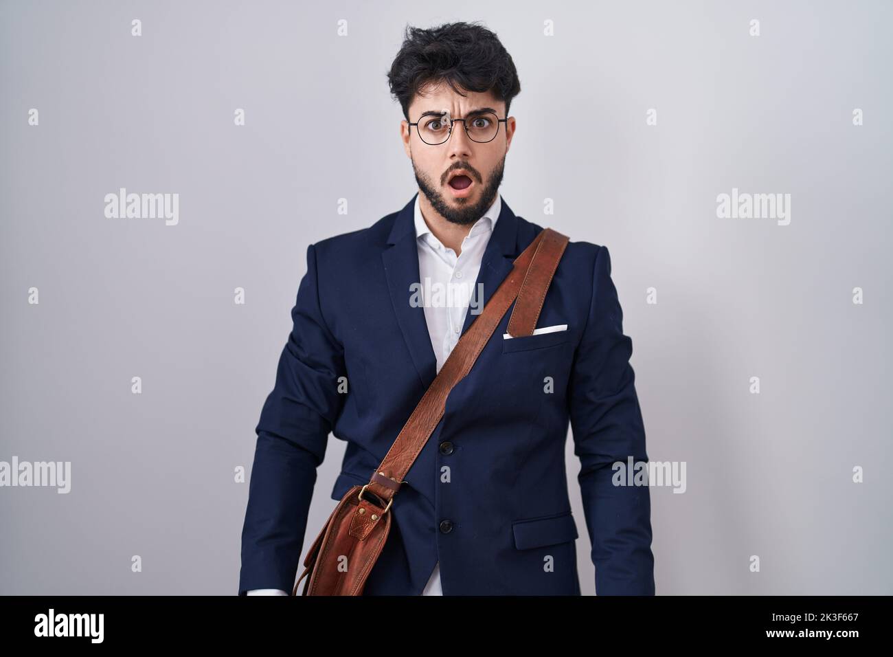 Hispanic man with beard wearing business clothes afraid and shocked ...
