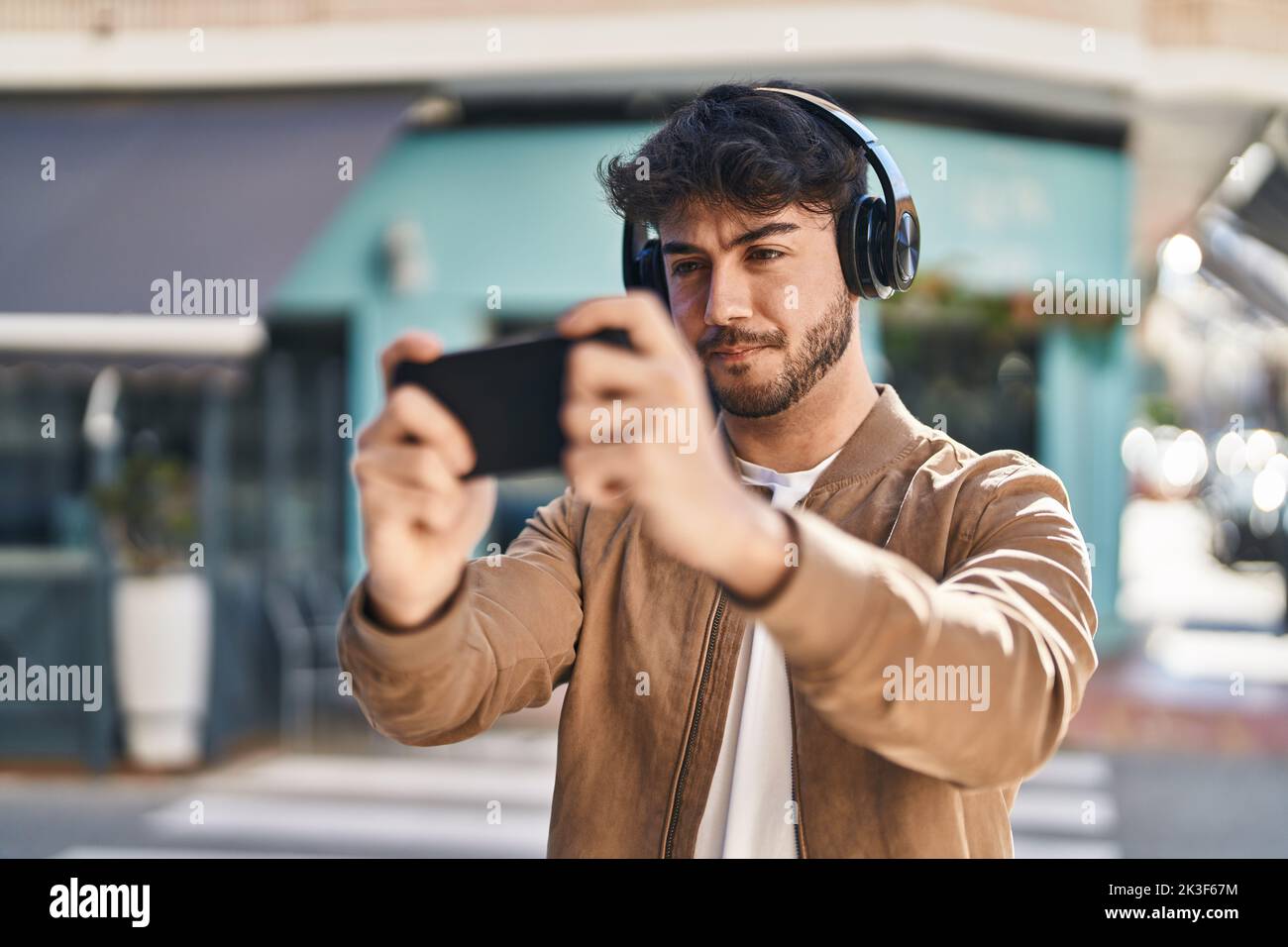 Young hispanic man playing video game at street Stock Photo - Alamy