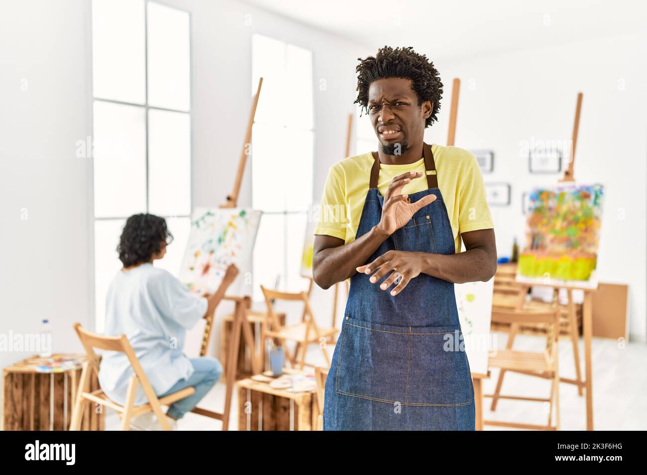 African young man standing at art studio disgusted expression ...