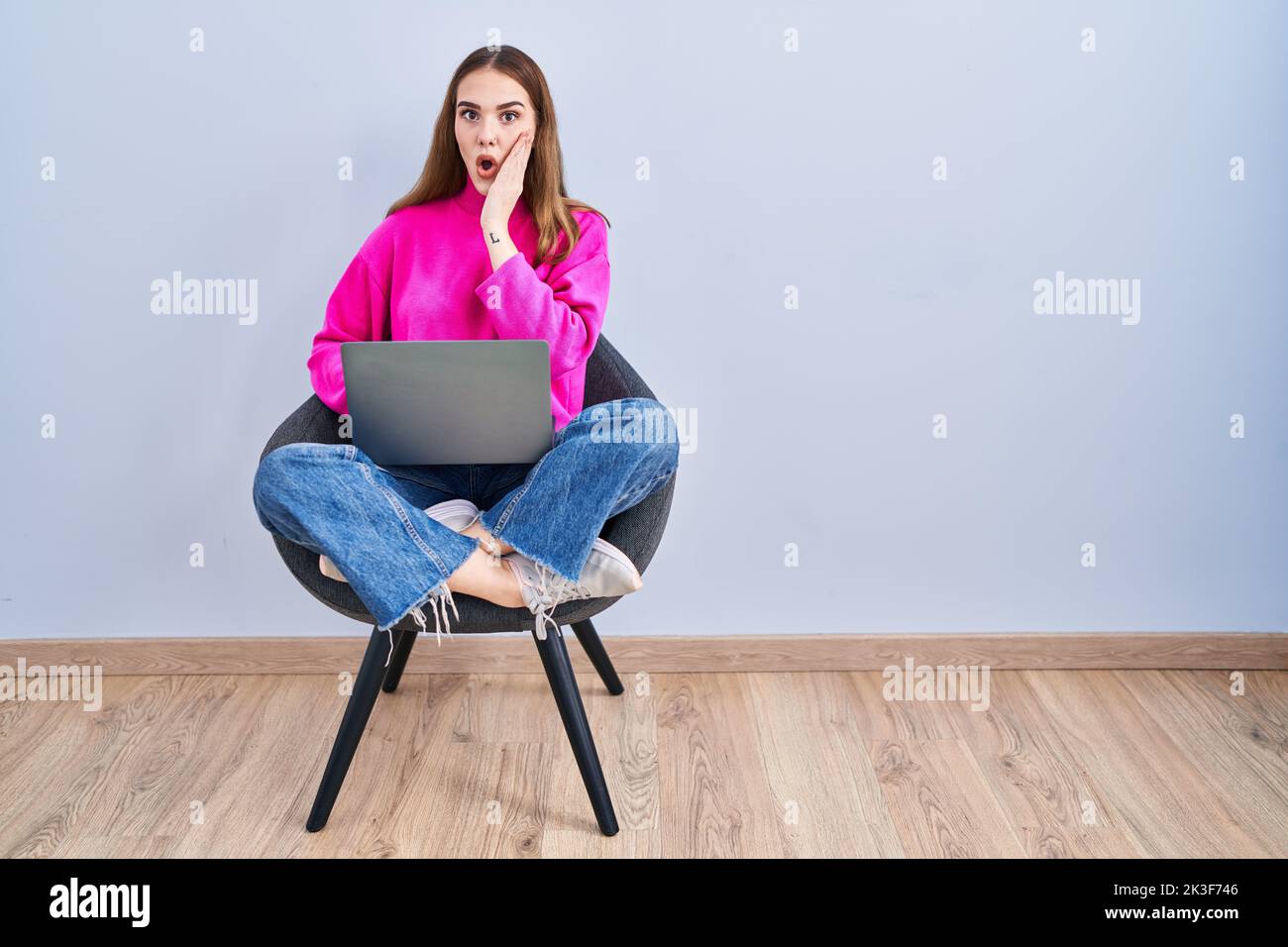 Young hispanic girl working using computer laptop afraid and shocked ...