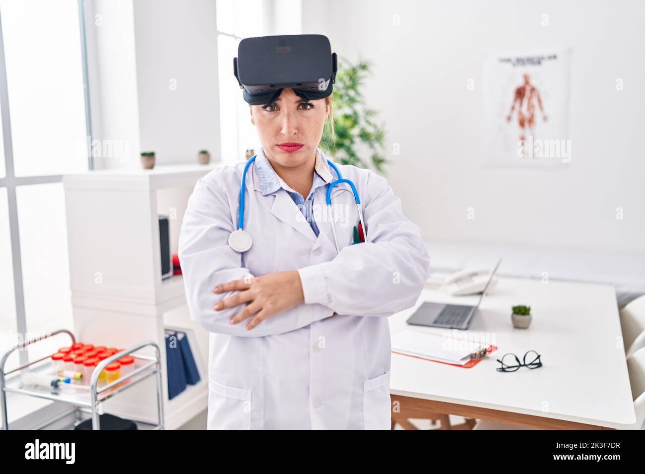Young hispanic doctor woman wearing doctor uniform and virtual reality ...