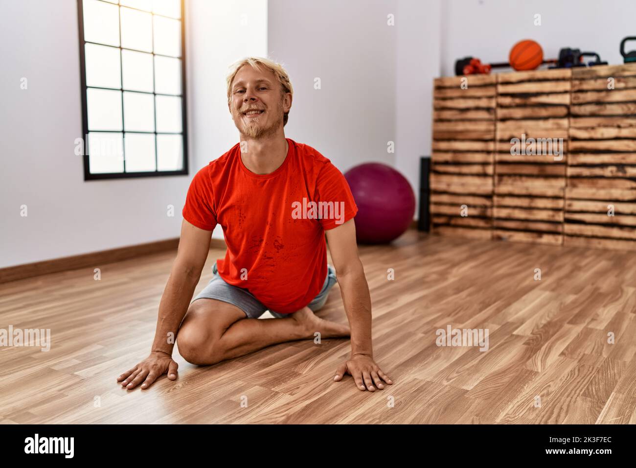 Young caucasian man smiling confident stretching at sport center Stock ...