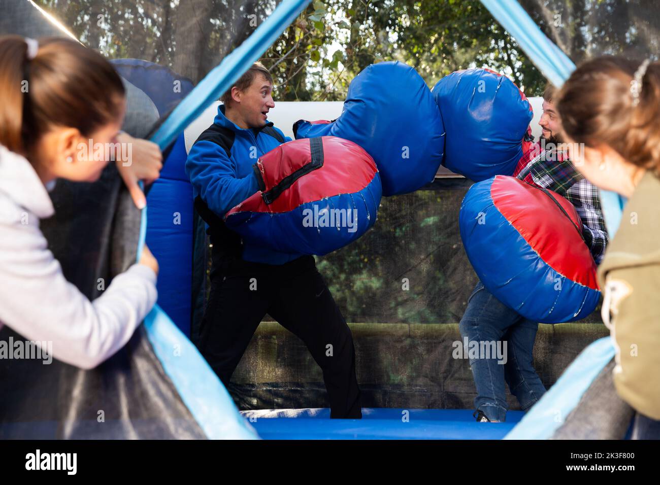 Male friends fighting at amusement playground Stock Photo - Alamy