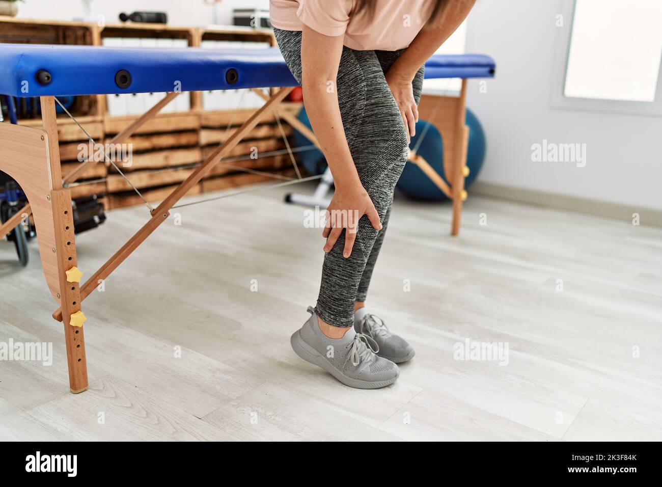 Middle age hispanic woman with leg pain at physiotherapy clinic Stock ...