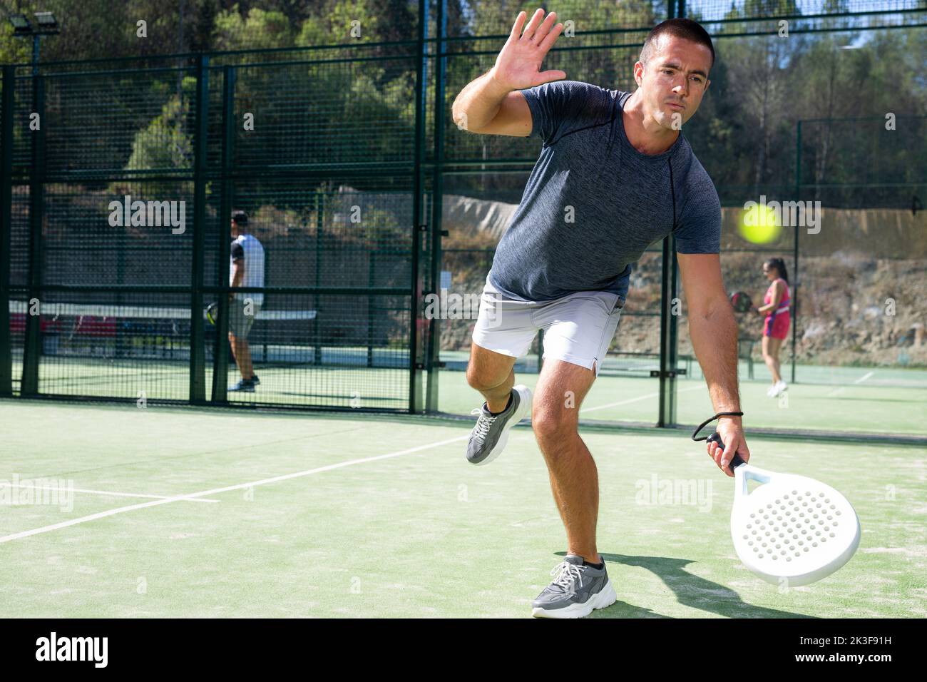 Male players playing padel in a padel court outdoor behind net Stock ...