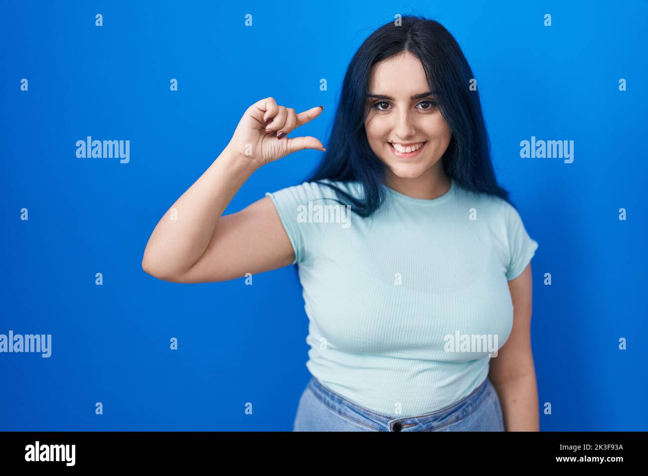 Young Modern Girl With Blue Hair Standing Over Blue Background Smiling 9461