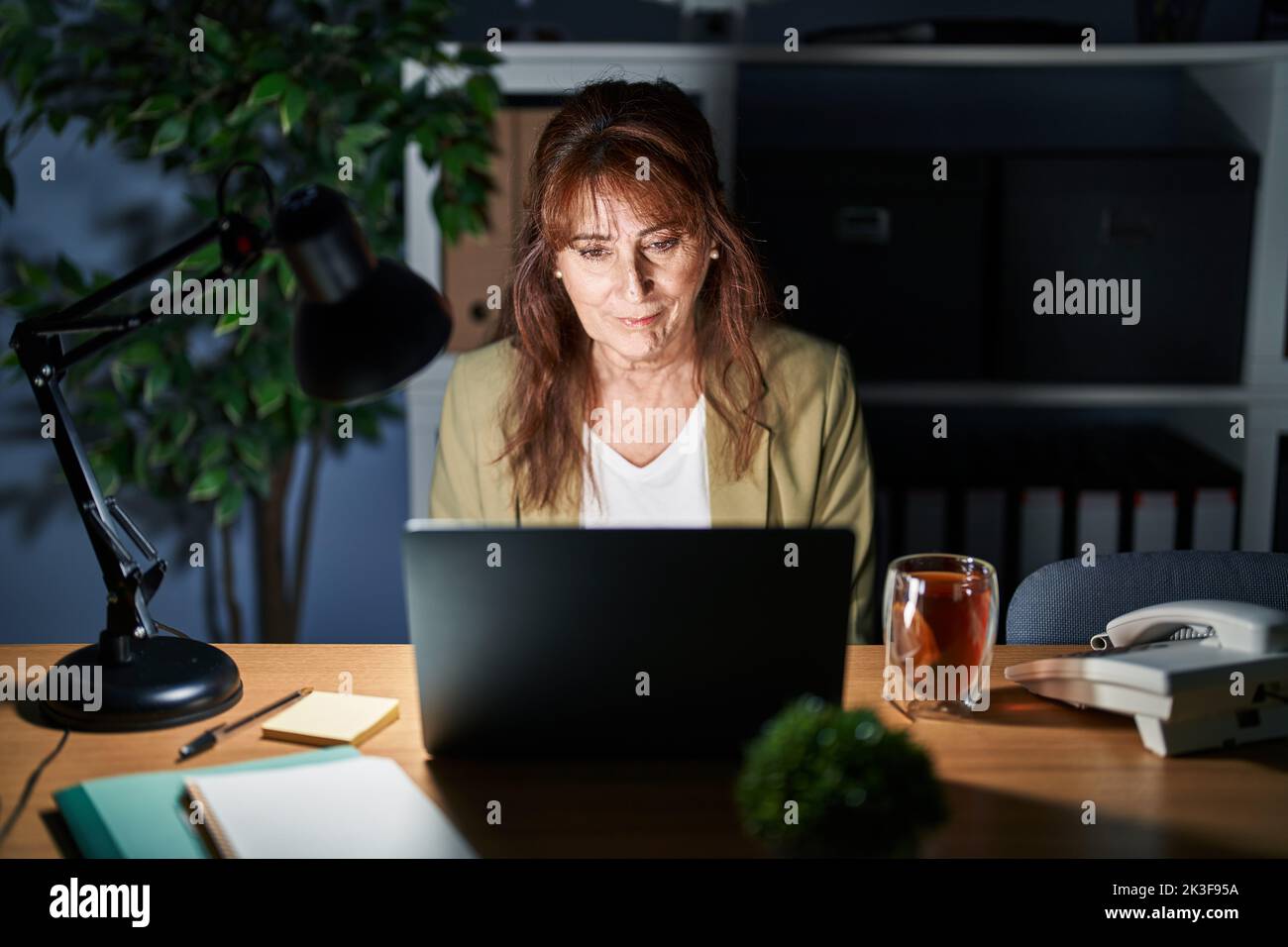 Middle age hispanic woman working using computer laptop at night ...