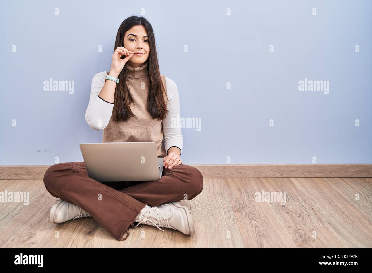 Young brunette woman working using computer laptop sitting on the floor ...