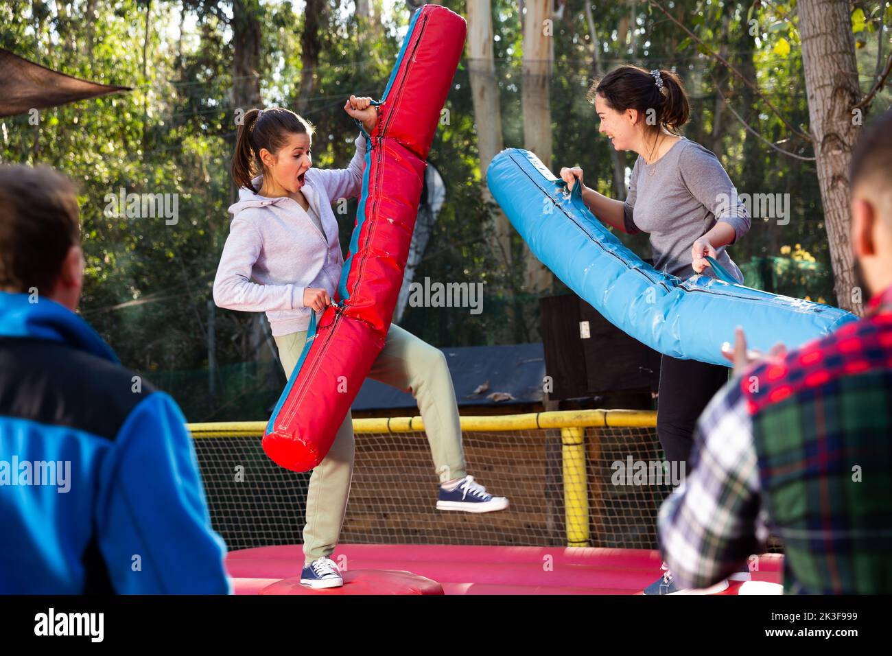 Female friends fighting by inflatable logs Stock Photo - Alamy